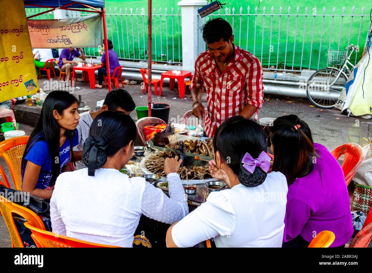 Young People Eating Street Food From A Stall In Downtown Yangon, Yangon ...
