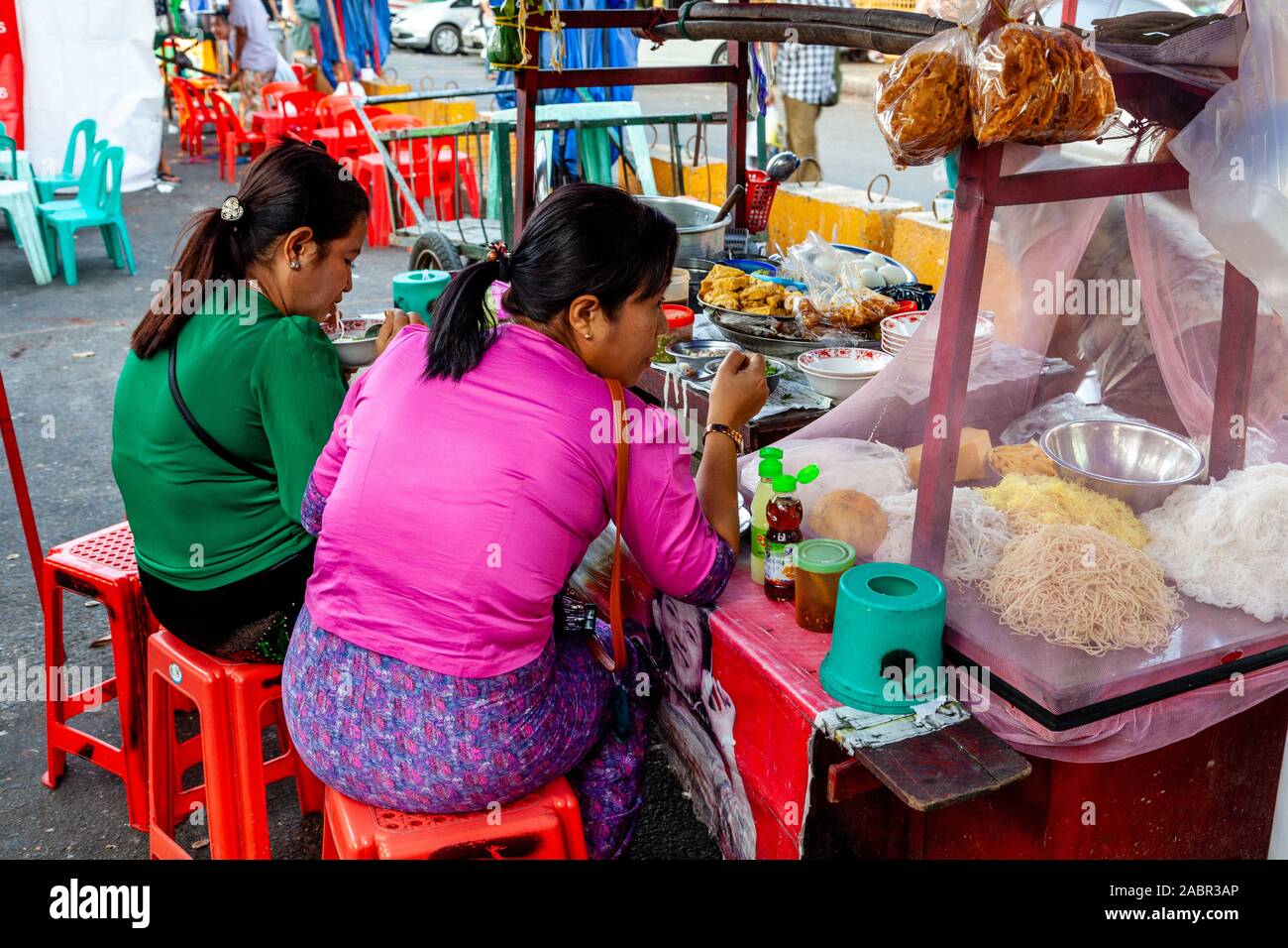 Two Women Eating Street Food From A Stall In Downtown Yangon, Yangon ...