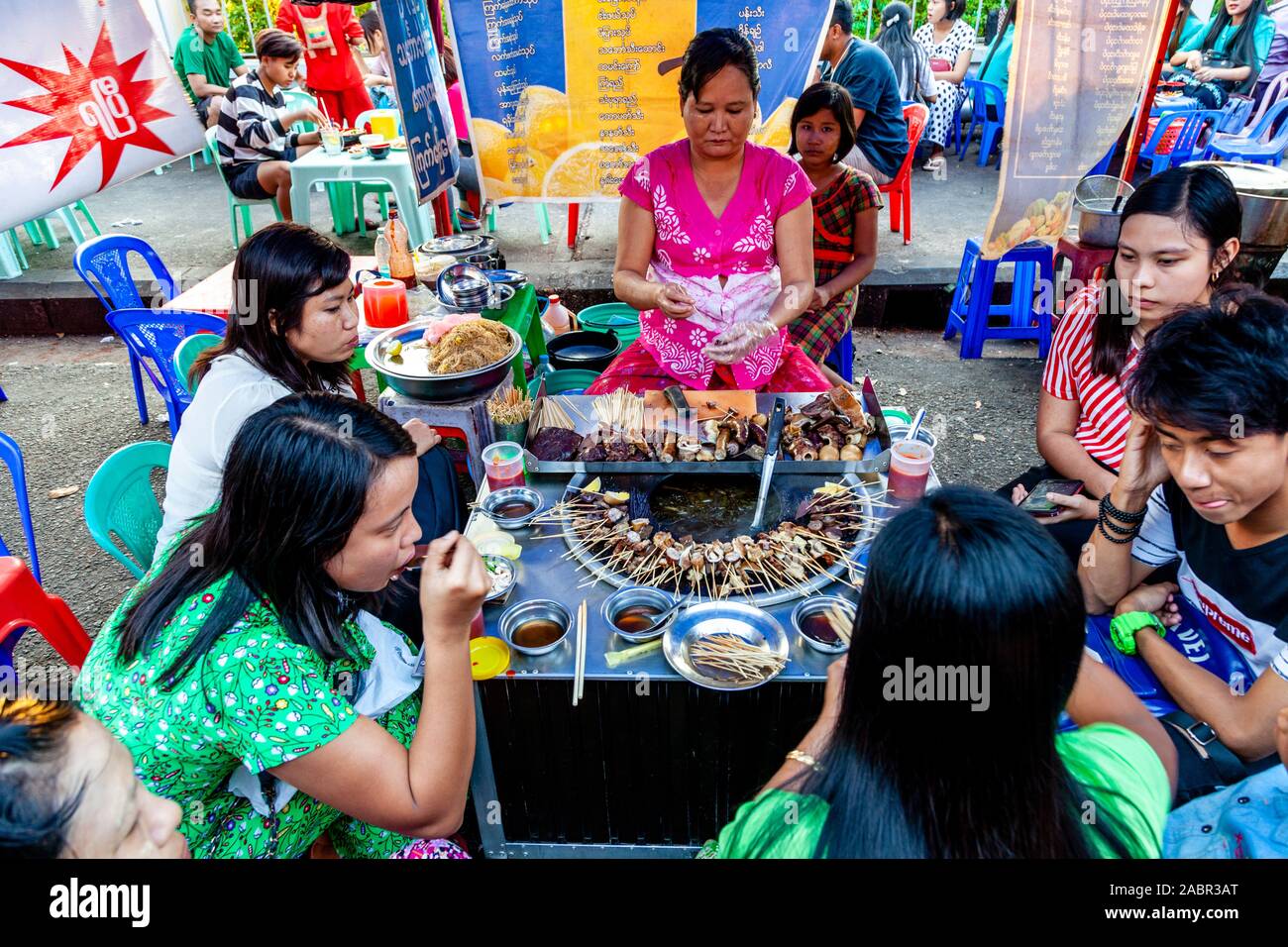 A Group Of Young People Eating Street Food From A Stall In Downtown ...