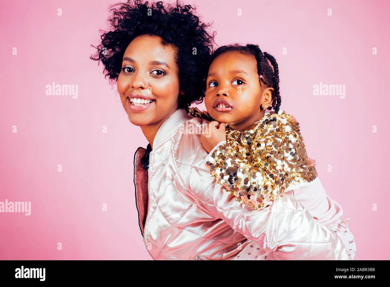 young pretty african-american mother with little cute daughter hugging ...