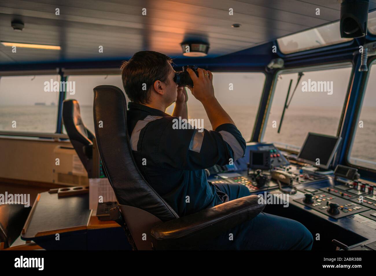 Navigational officer lookout on navigation watch looking through ...