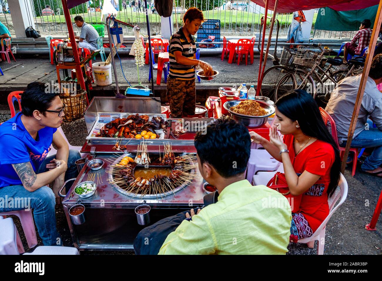 A Group Of Young People Eating Street Food From A Stall In Downtown ...