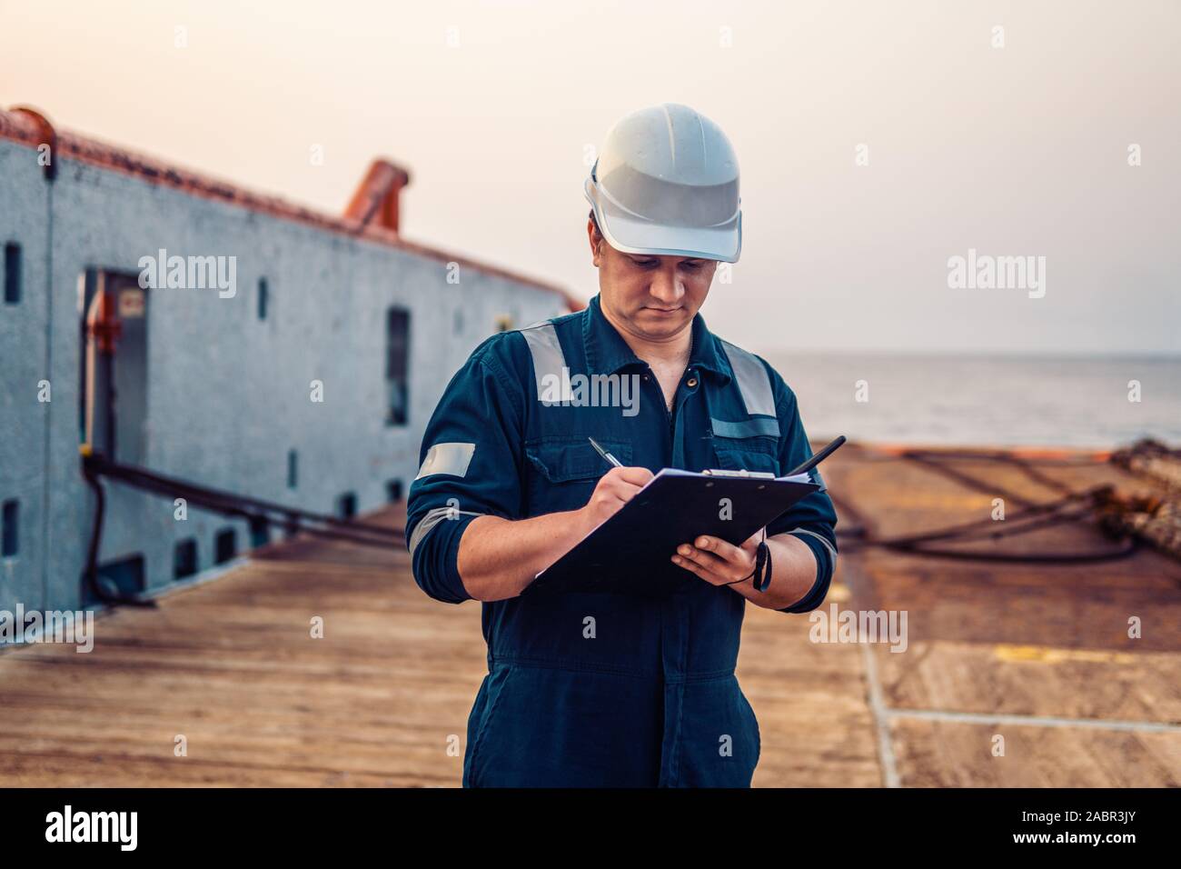 Deck Officer on deck of offshore vessel or ship , wearing PPE personal ...