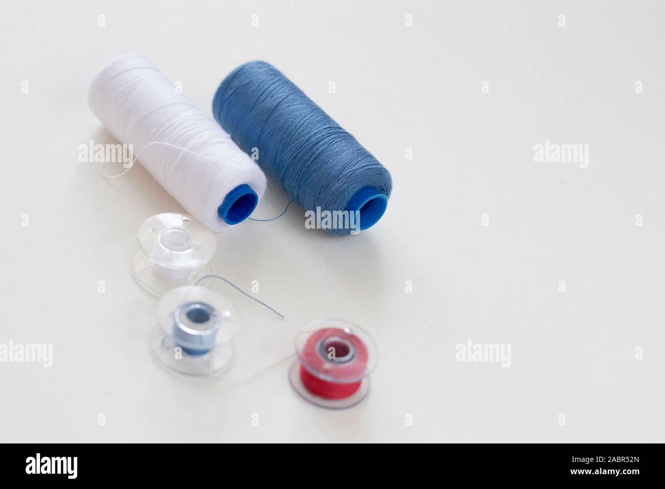 Sewing accessories on a light background close-up. Multi-colored spools ...