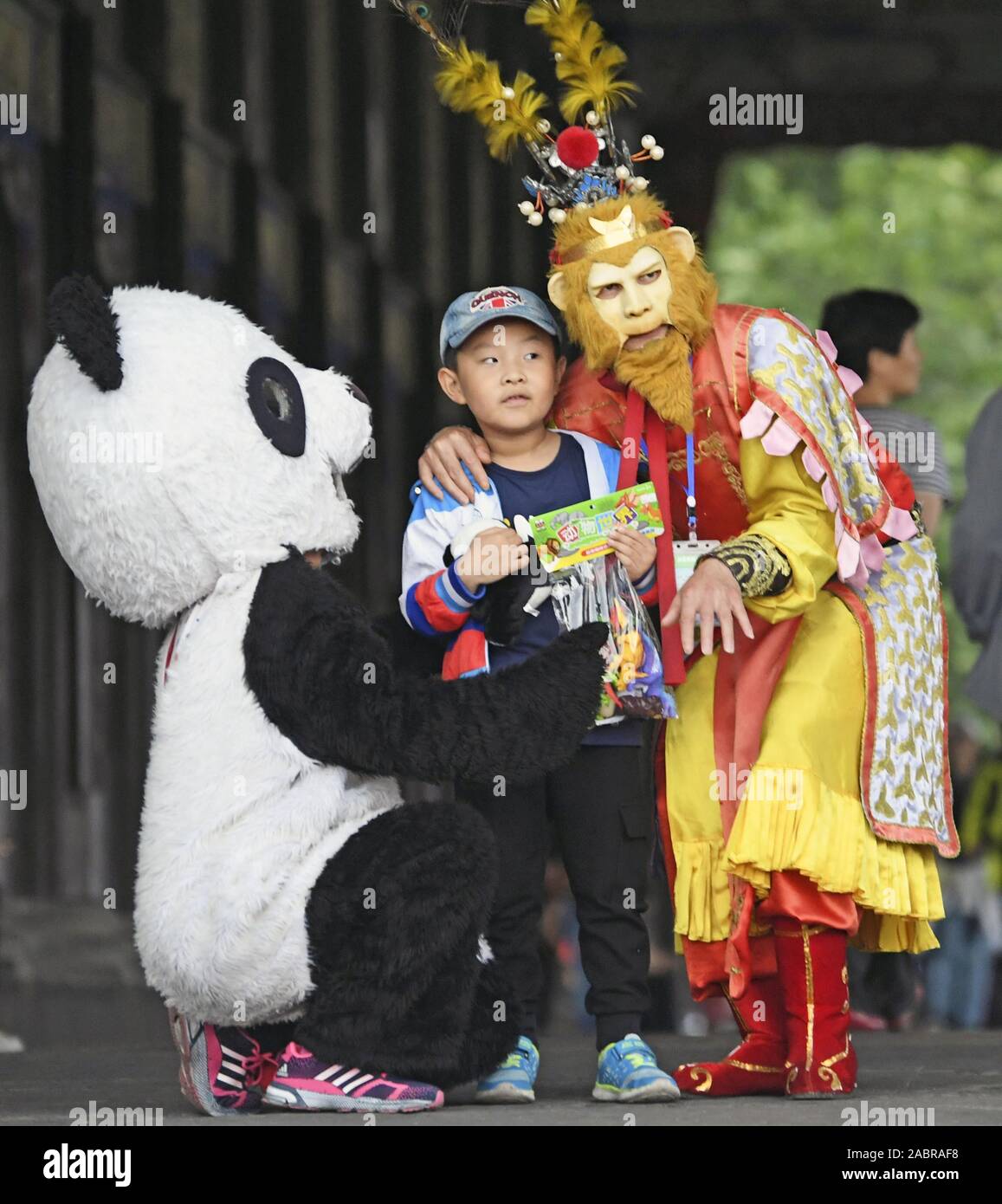 A boy looks a little intimidated by two mascots -- a sneaker-wearing ...