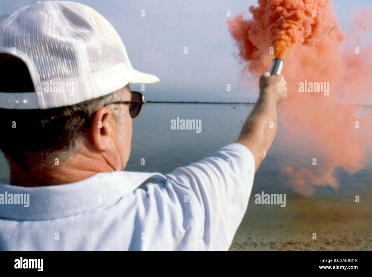 Man holding a lit flare for rescue patrol to find him ca. 1980 Stock ...