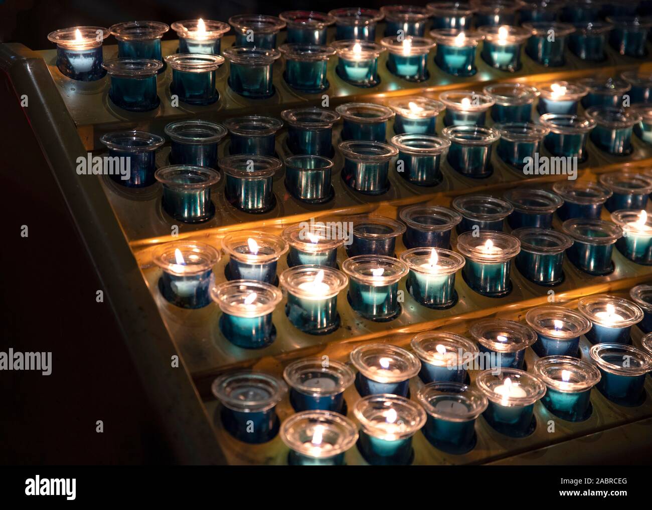 Group of candles lit in a church Stock Photo - Alamy