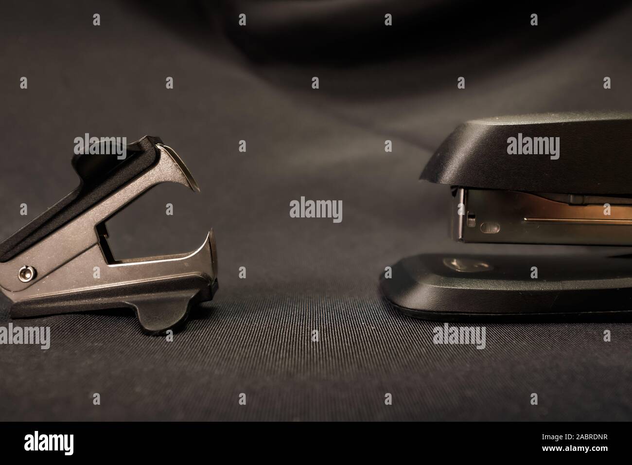 Stapler verses staple remover Office conflict example Stock Photo - Alamy