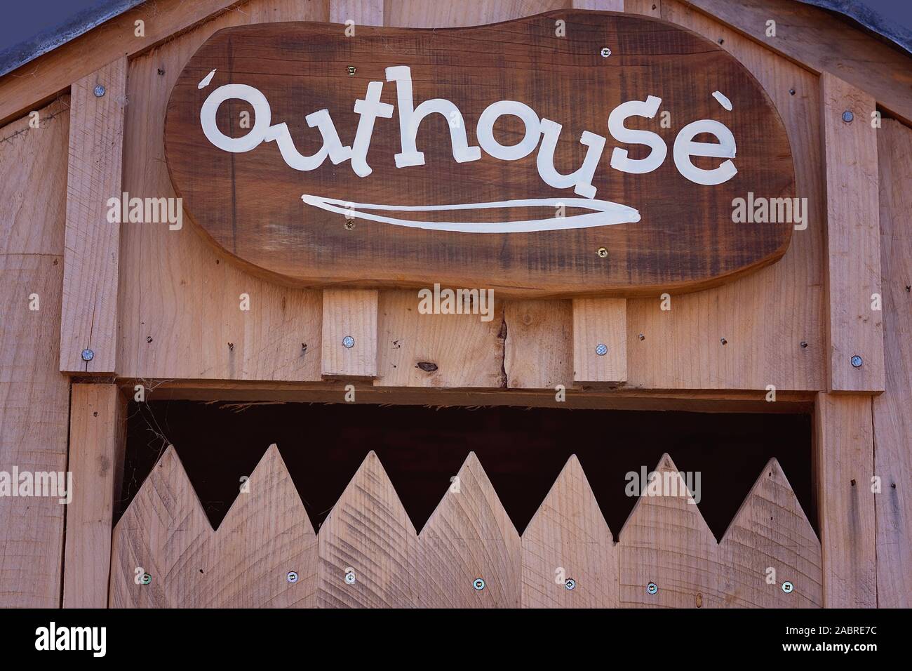 A timber outdoor lavatory with humorous sign Stock Photo - Alamy