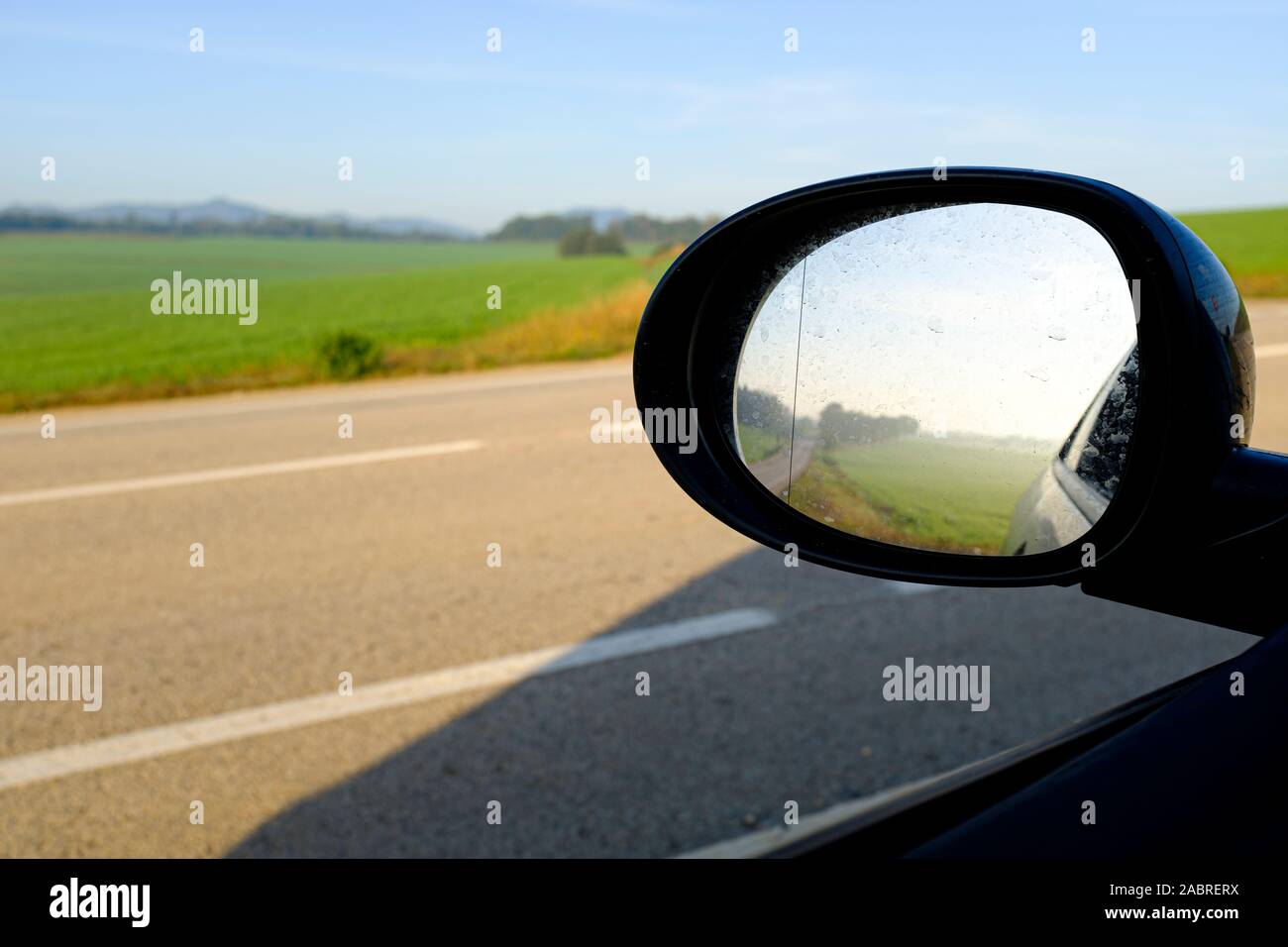 Black left oval mirror car reflection on a plain green landscape Stock ...