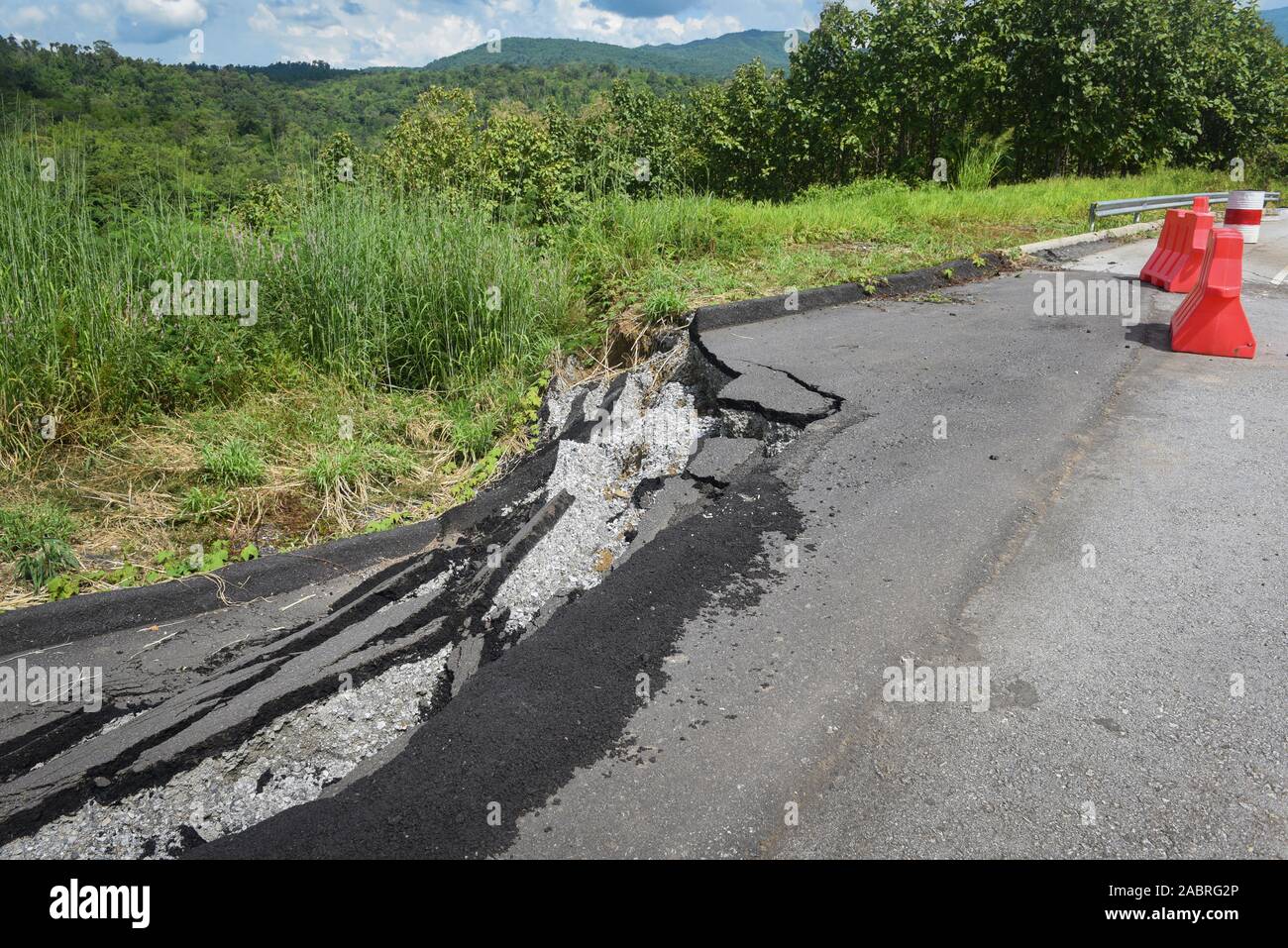 Asphalt road collapsed and cracks in the roadside / Road landslide ...