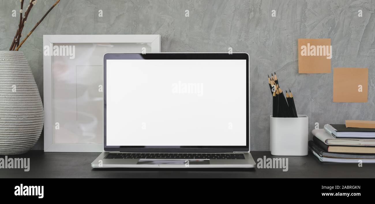 Modern workplace with open blank screen laptop computer and office ...