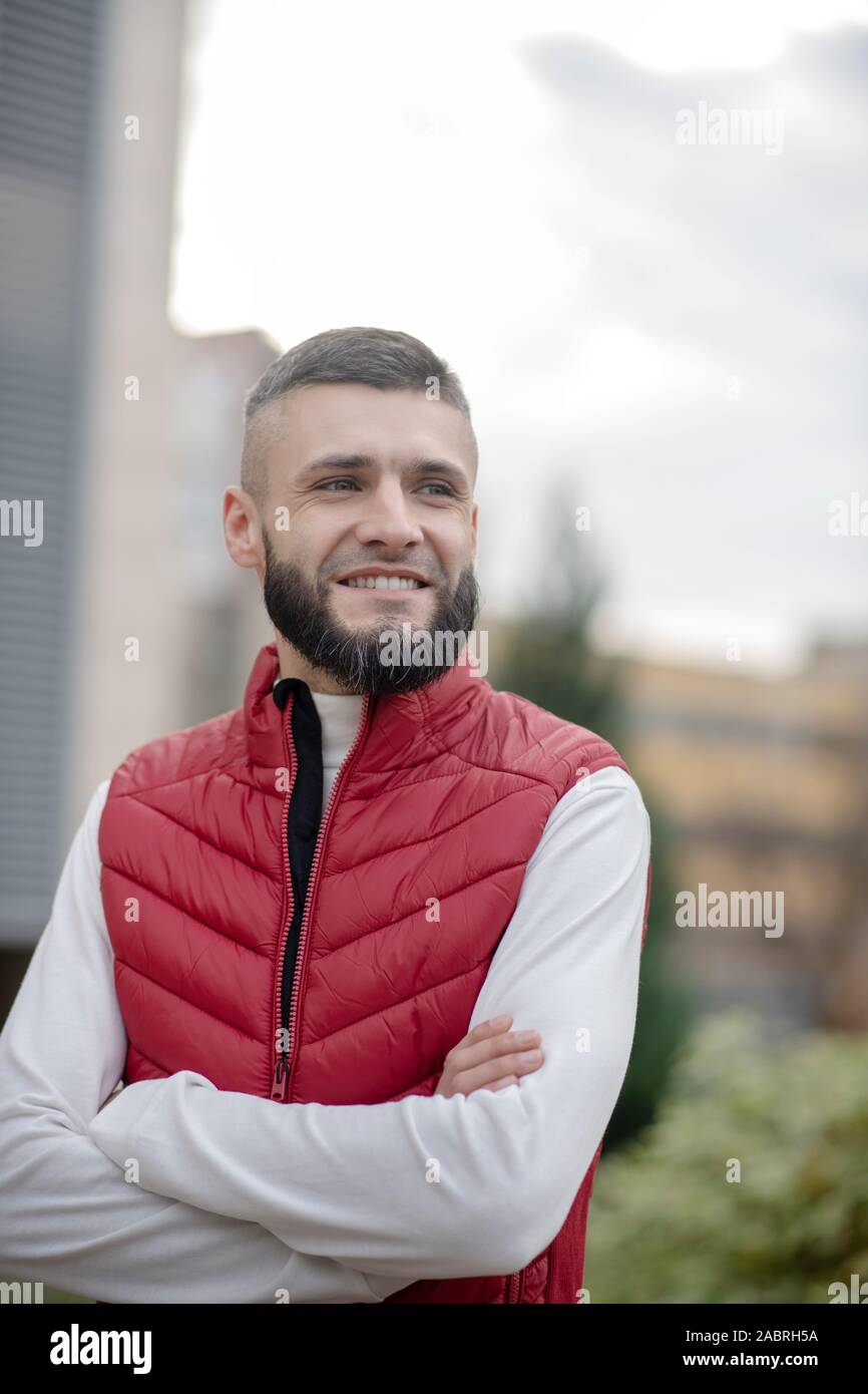 Positive man. Handsome young man smiling while standing cross handed ...