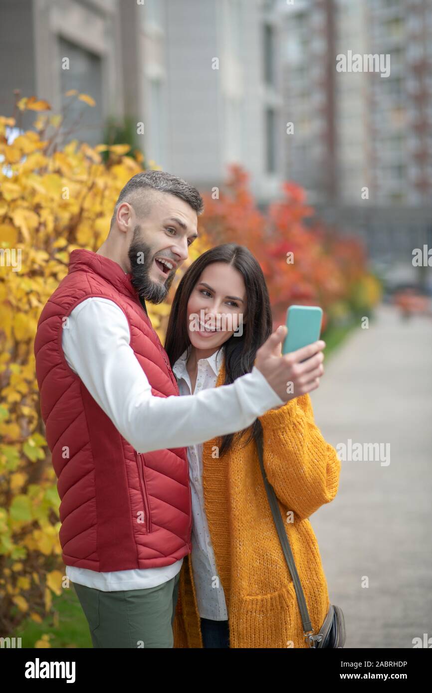 Remembering moments. Nice happy couple smiling while talking photos on ...