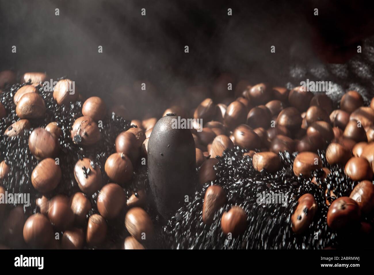 Close-up of Chestnut roasting with black pebble fresh and hot In Big ...