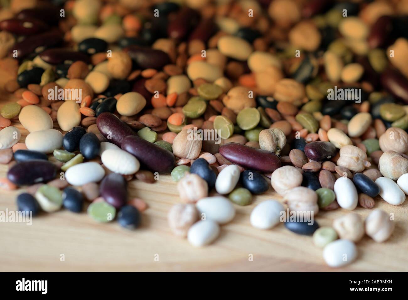 Different beans scattered on a wooden surface close-up. Naturel organic ...