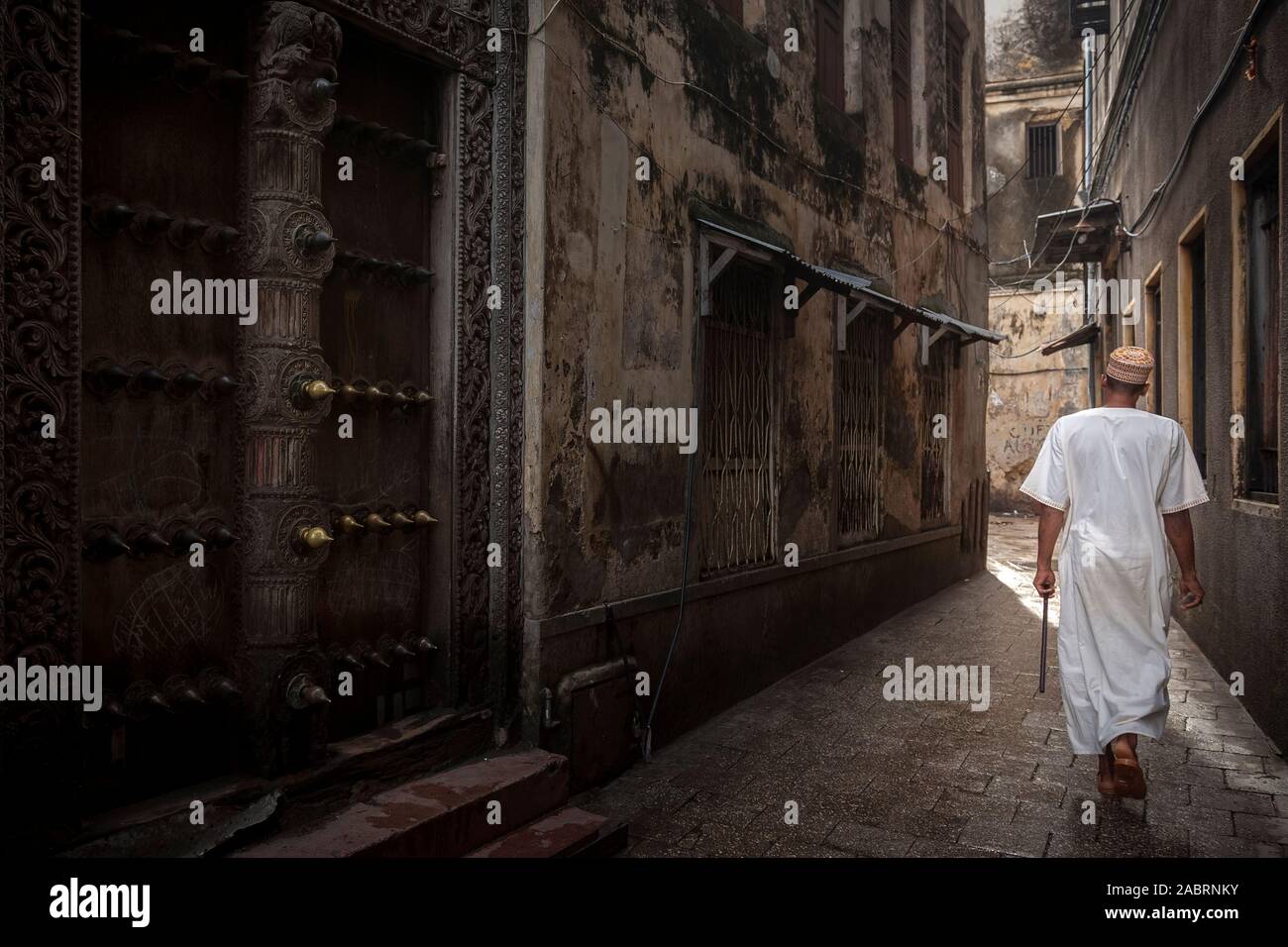 islamic man walking through narrow streets of Stonetown Stock Photo - Alamy