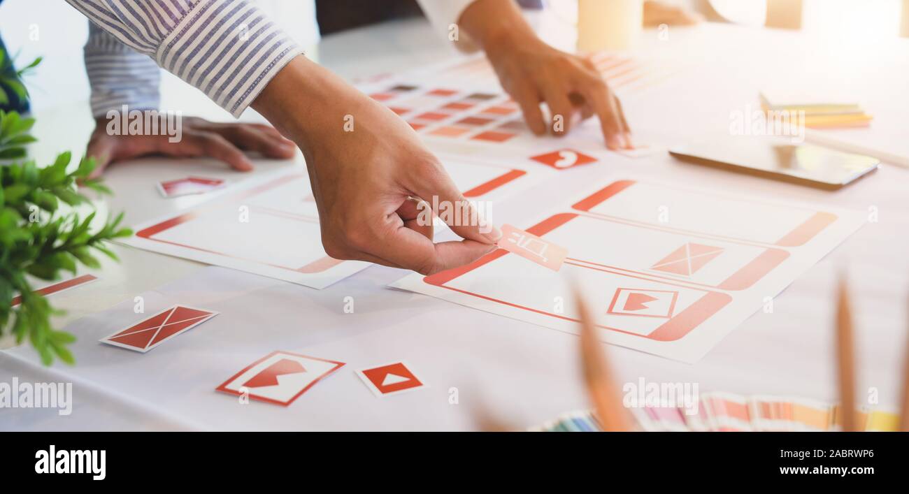 Close-up view of young professional UI web developer team editing their ...