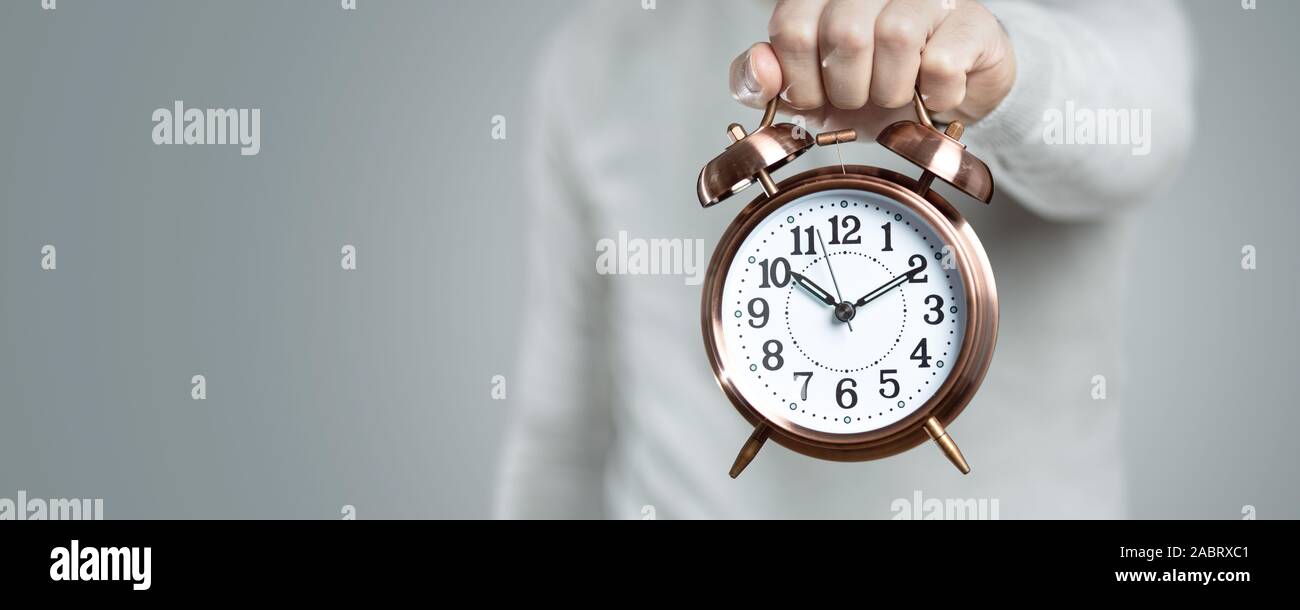 Retro clock held by the hand of a man Stock Photo - Alamy