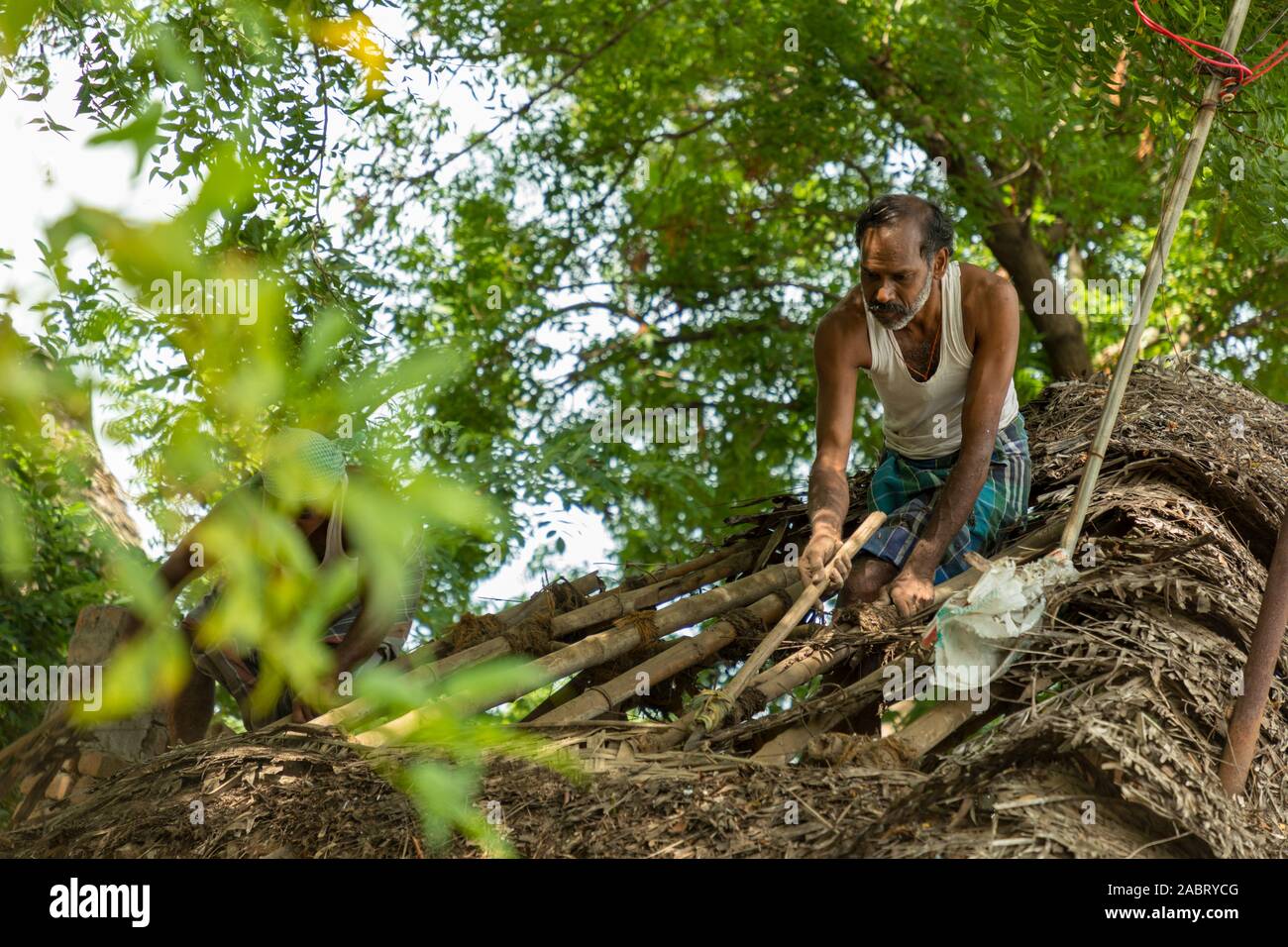 people change hut, The men replace the roof in a hut Stock Photo - Alamy