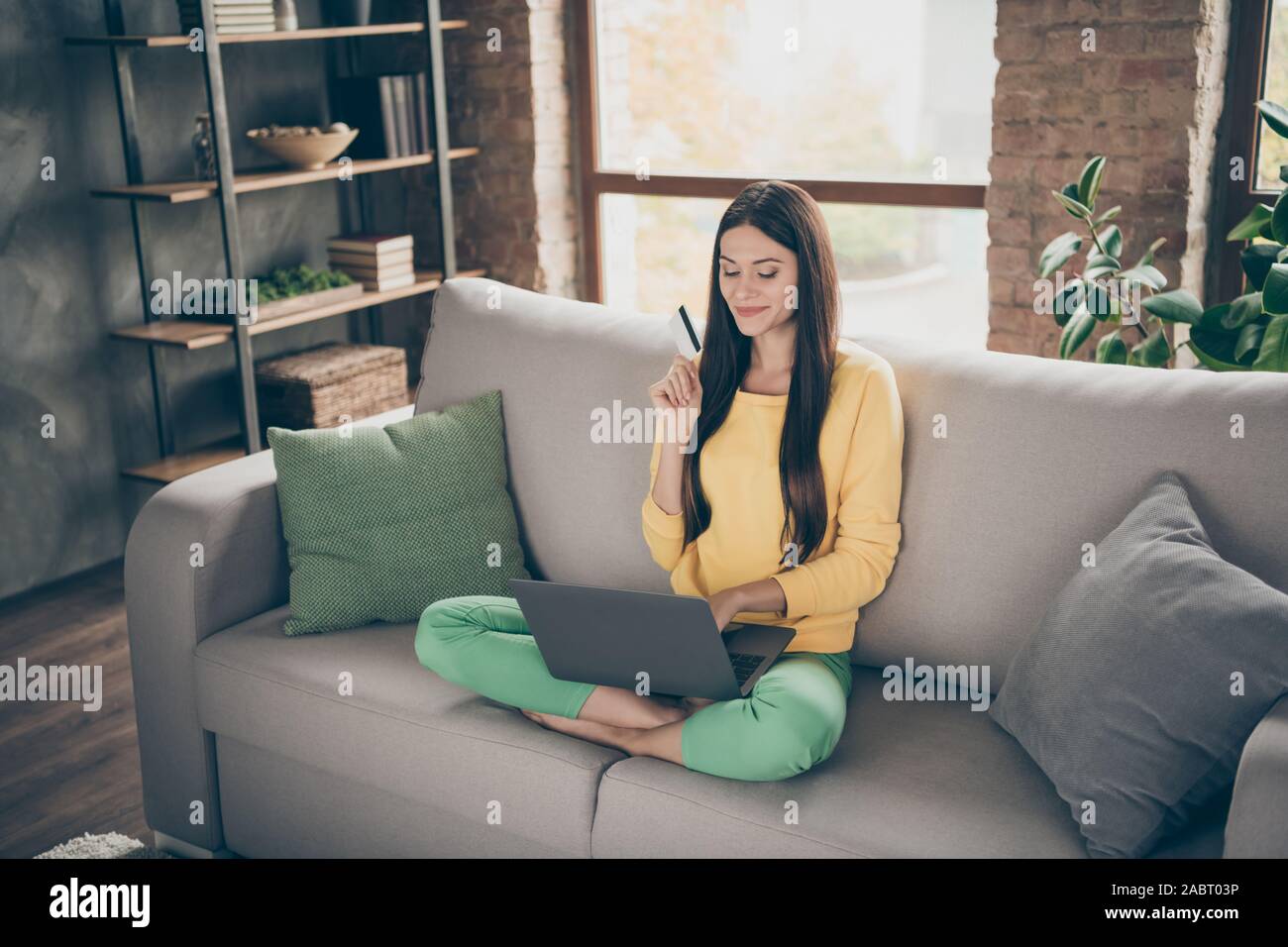 Full Length Photo Of Positive Cheerful Girl Sit Divan Legs Crossed Use