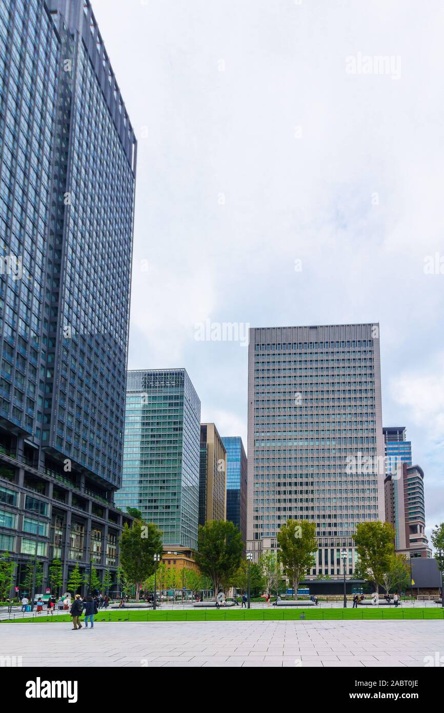Tokyo, Japan - October 19, 2019: View of the Tokyo station square, with office buildings, locals ...