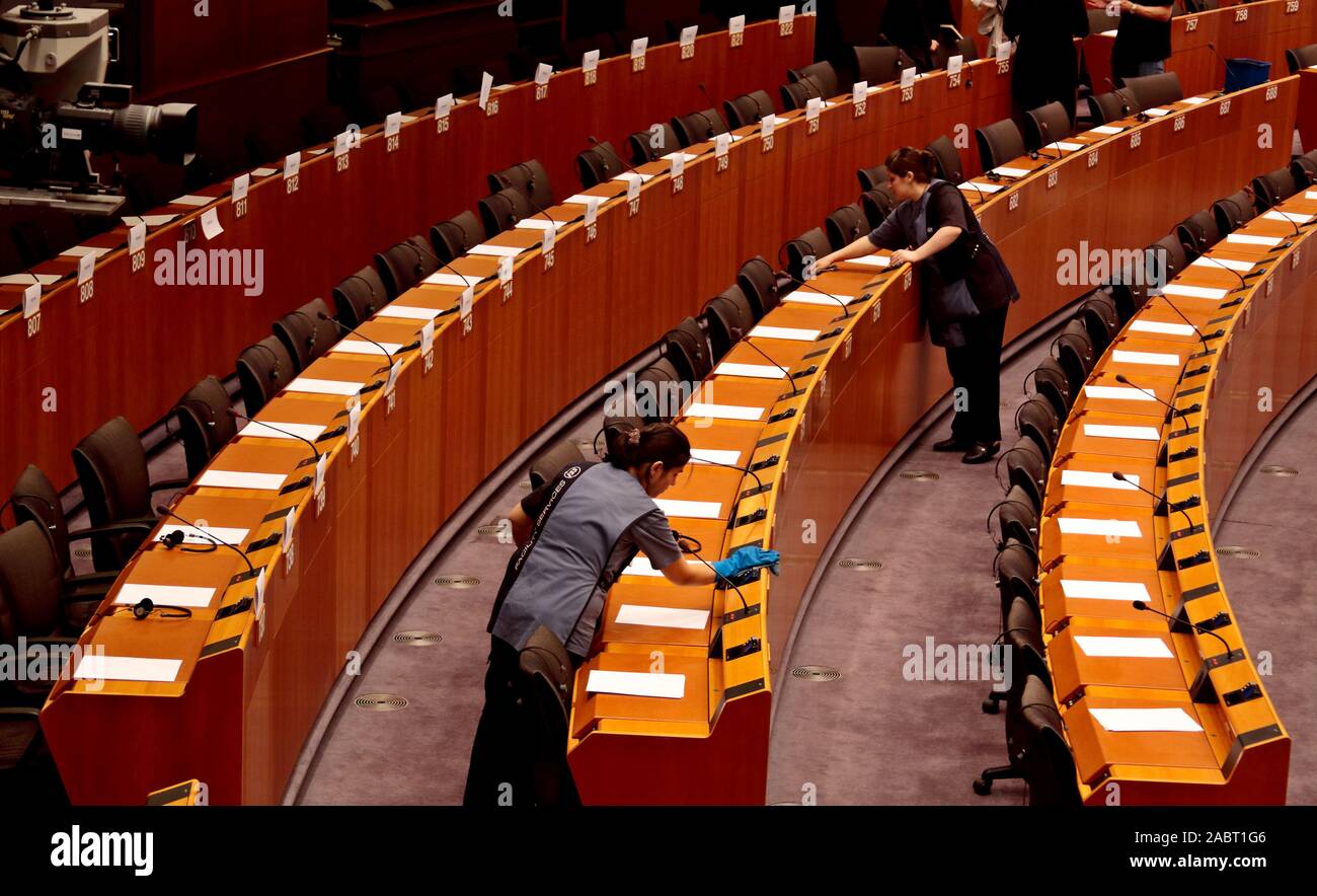 Cleaning ladies dusting tables in EU parliament chamber before meeting ...