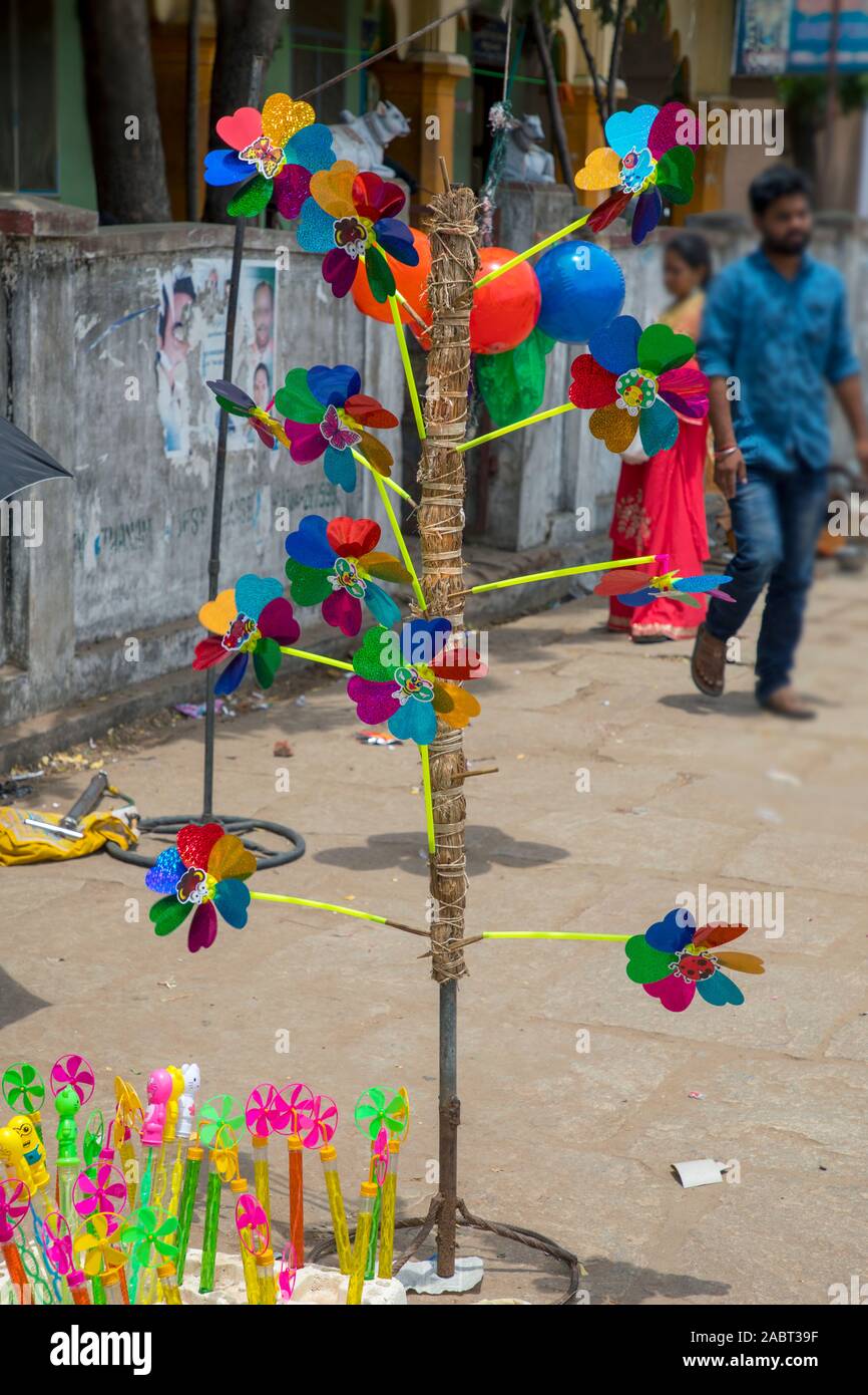 vendor selling colorful plastic windmill on Indian temple festival ...