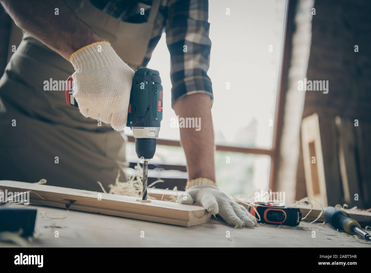Cropped clsoe up photo of man drilling wood equipped with gloves doing ...