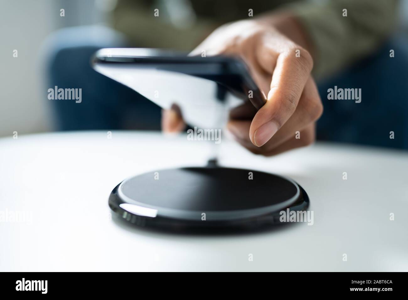 Man Charging Smartphone Using Wireless Charging Pad At Home Stock Photo ...