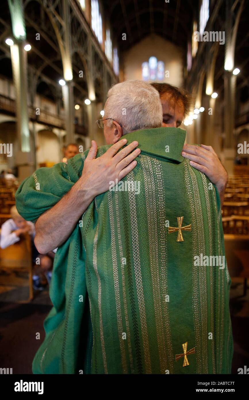 Catholic priest hugged by his parishioners after his last mass at Notre ...