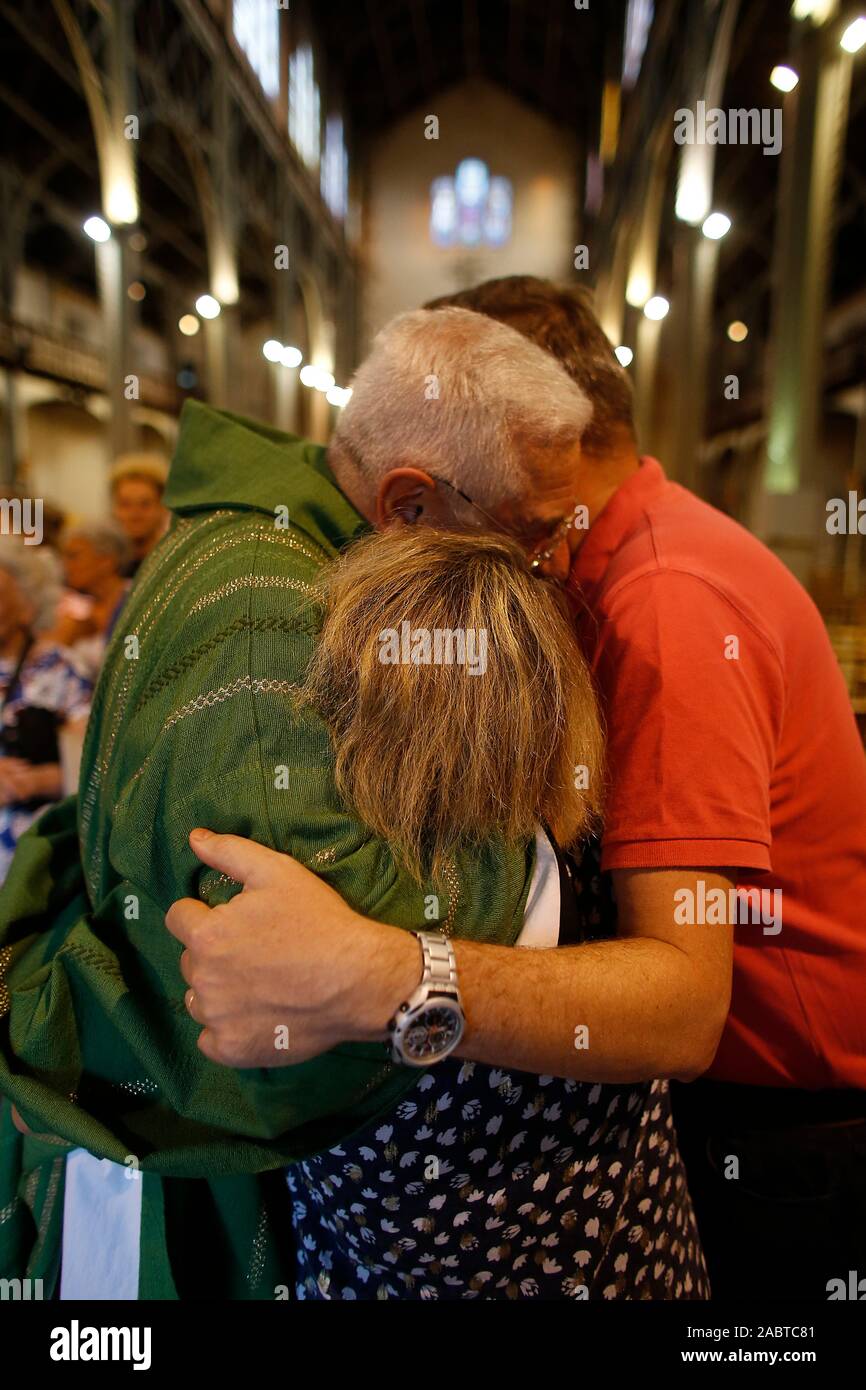 Catholic priest hugged by his parishioners after his last mass at Notre ...