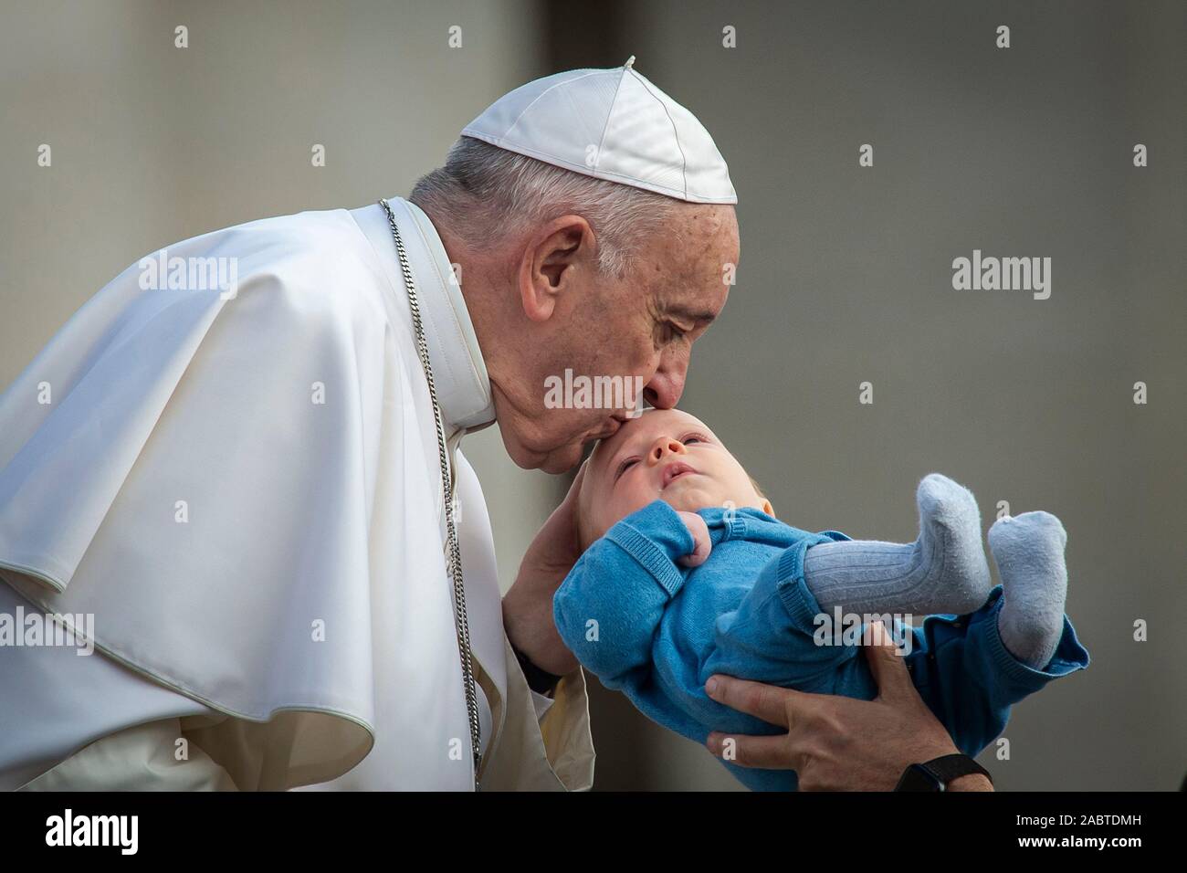 Pope Francis kisses a child as he arrives for his weekly general ...