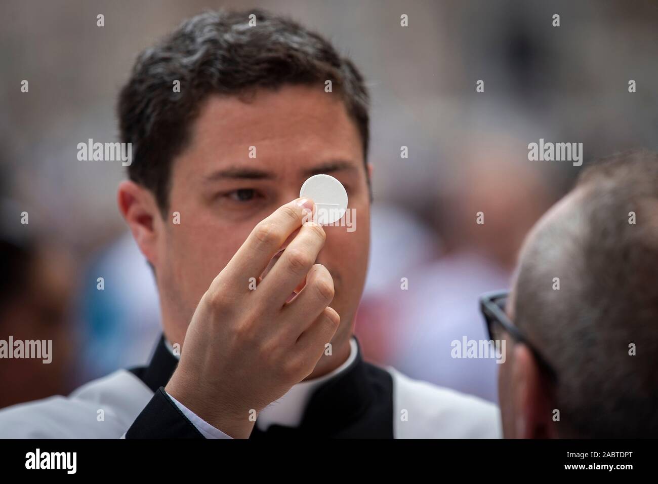 A priest gives holy communion during Pentecost Holy Mass in St. Peter's ...