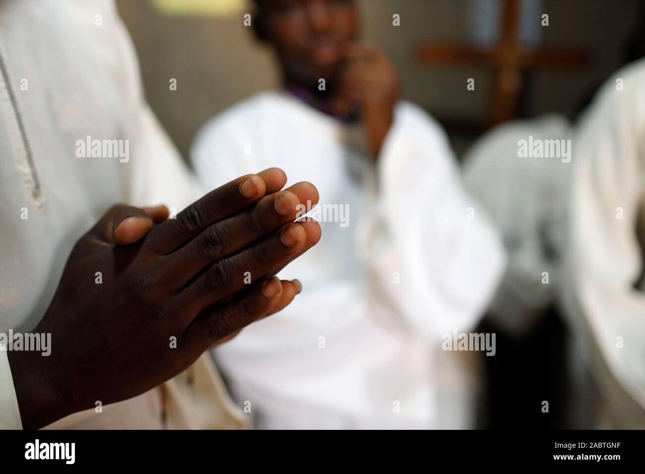 African church. Sunday catholic mass. Man praying. Close-up on hands ...