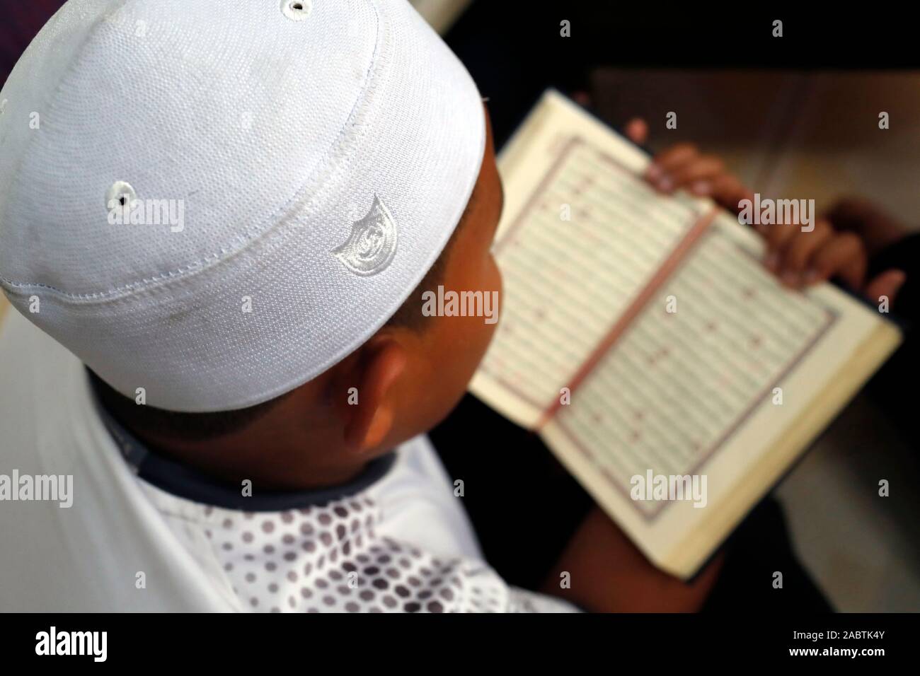 Muslim boy learning Quran at Islamic school. Kufi hat Stock Photo - Alamy