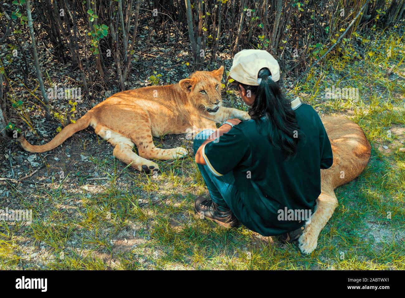 African woman kneeling on the ground and snuggling, embracing and ...