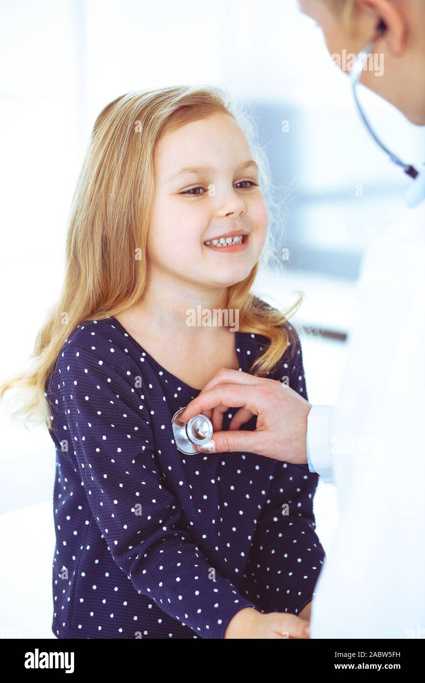 Doctor examining a child patient by stethoscope. Cute baby girl at ...
