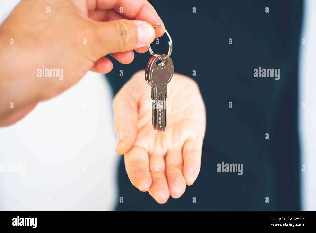 Young lady taking keys from female real estate agent during meeting ...