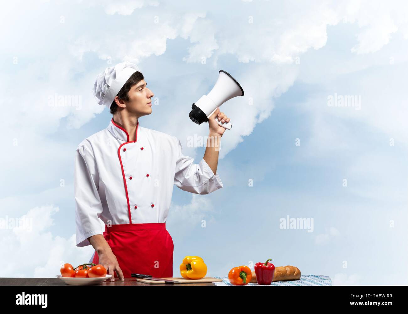 Young chef standing with megaphone in hand Stock Photo - Alamy