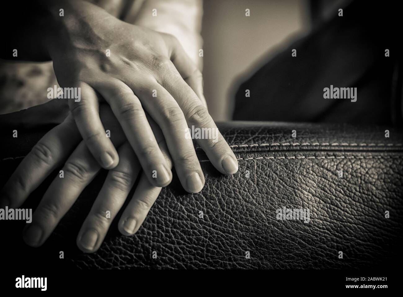 A close-up of female hands on a leather chair in black and white Stock ...