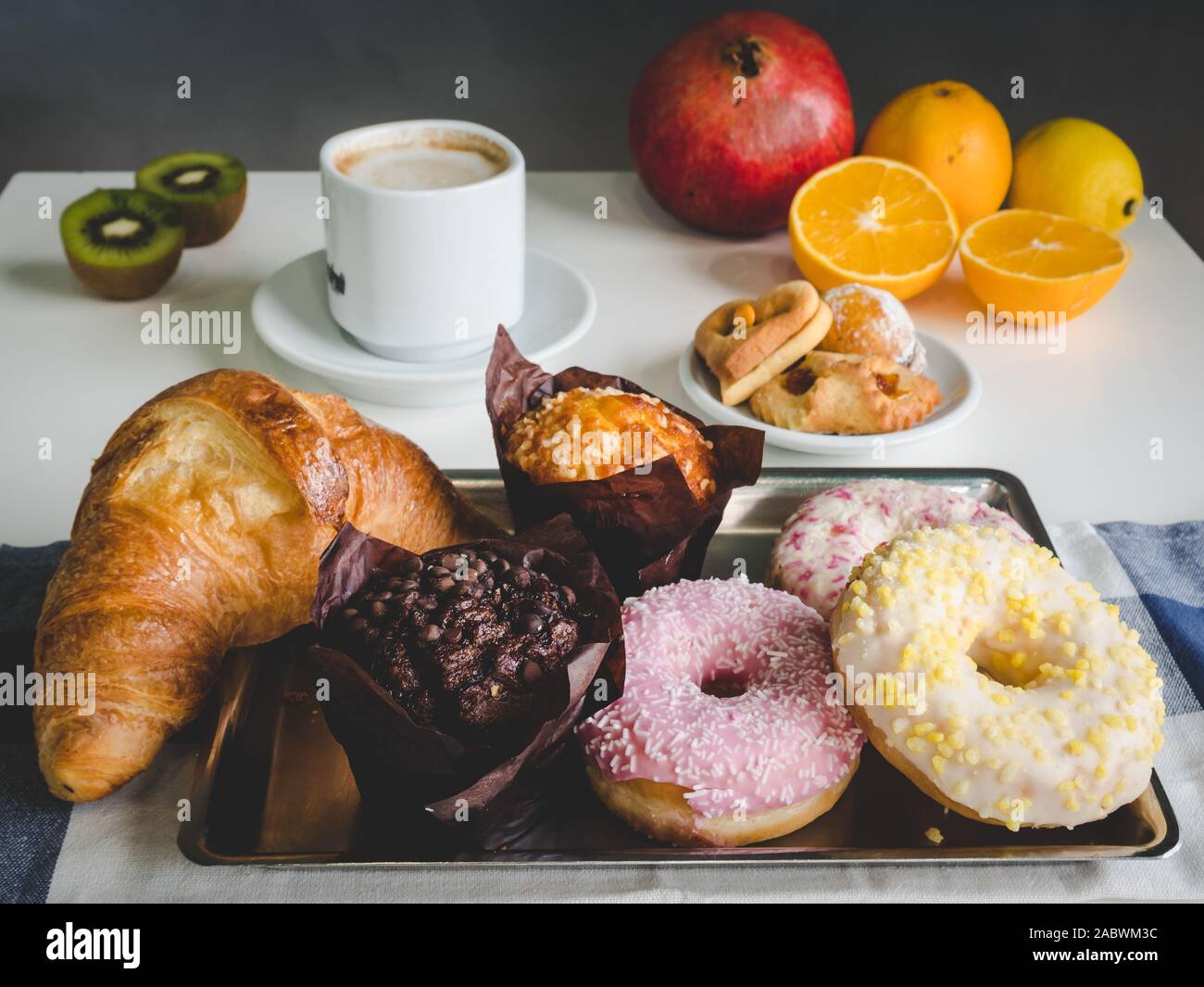 delicious breakfast with fruits, muffins, donuts and croissant. white ...