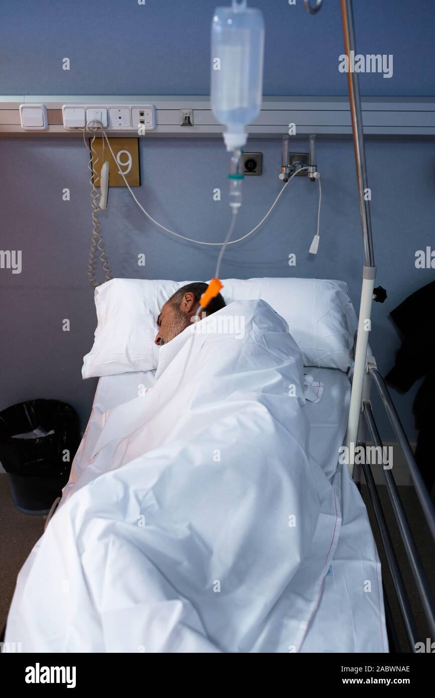 senior man plus year old man recovering from surgery in a hospital bed ...