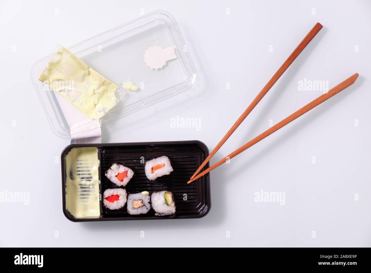 Opened plastic package with a half eaten fast food sushi from the ...