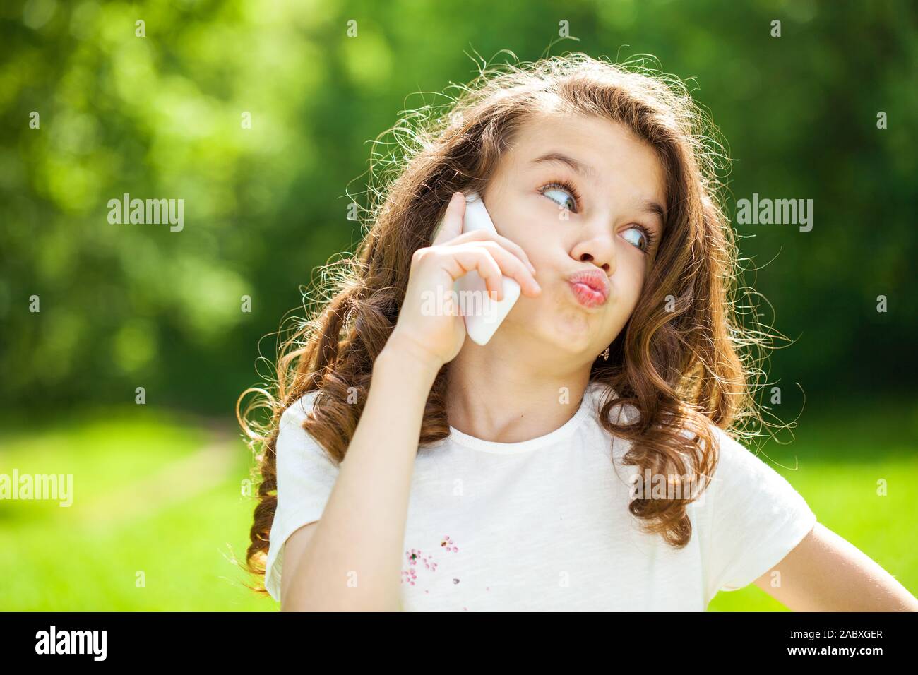 Beautiful little girl calling by mobile phone on the background of ...