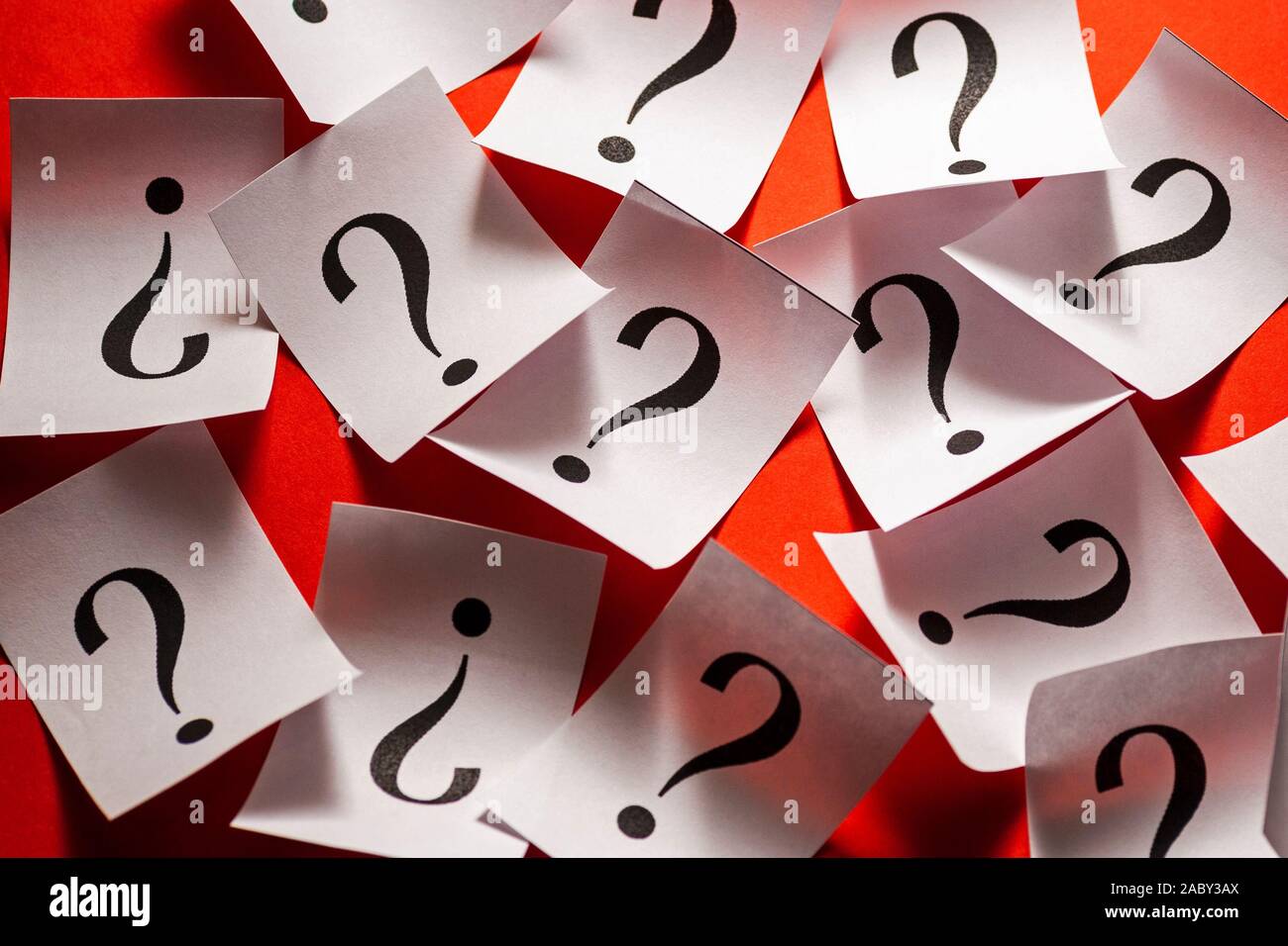 Randomly scattered question marks on white paper Stock Photo - Alamy