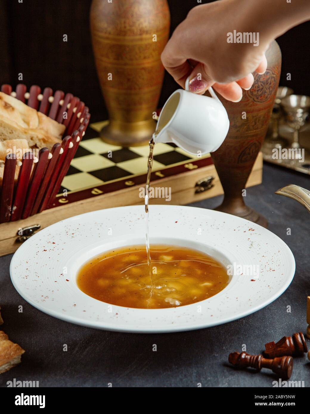 woman pouring vinegar into dushbara dumpling soup Stock Photo - Alamy
