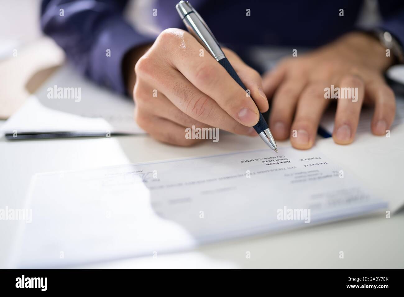 Close-up Of Human Hand Writing On Cheque Stock Photo - Alamy