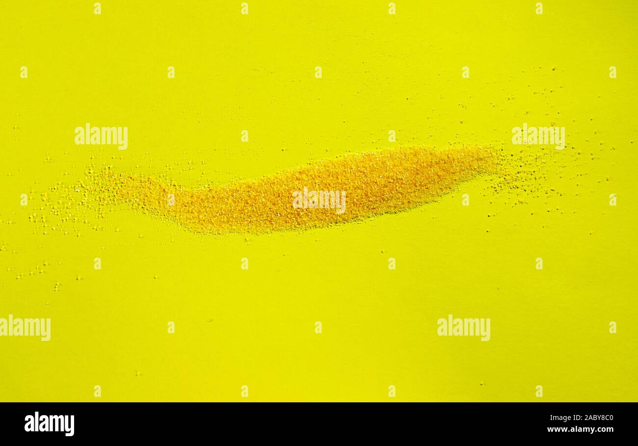 Yellow grains of cornmeal on colored background ,it’s a common staple ...