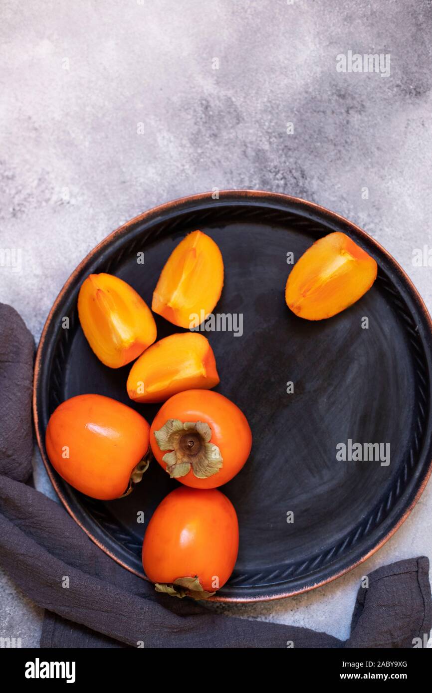 Persimmon on a vintage metal plate. Slices of fresh kaki or sharon. Top ...